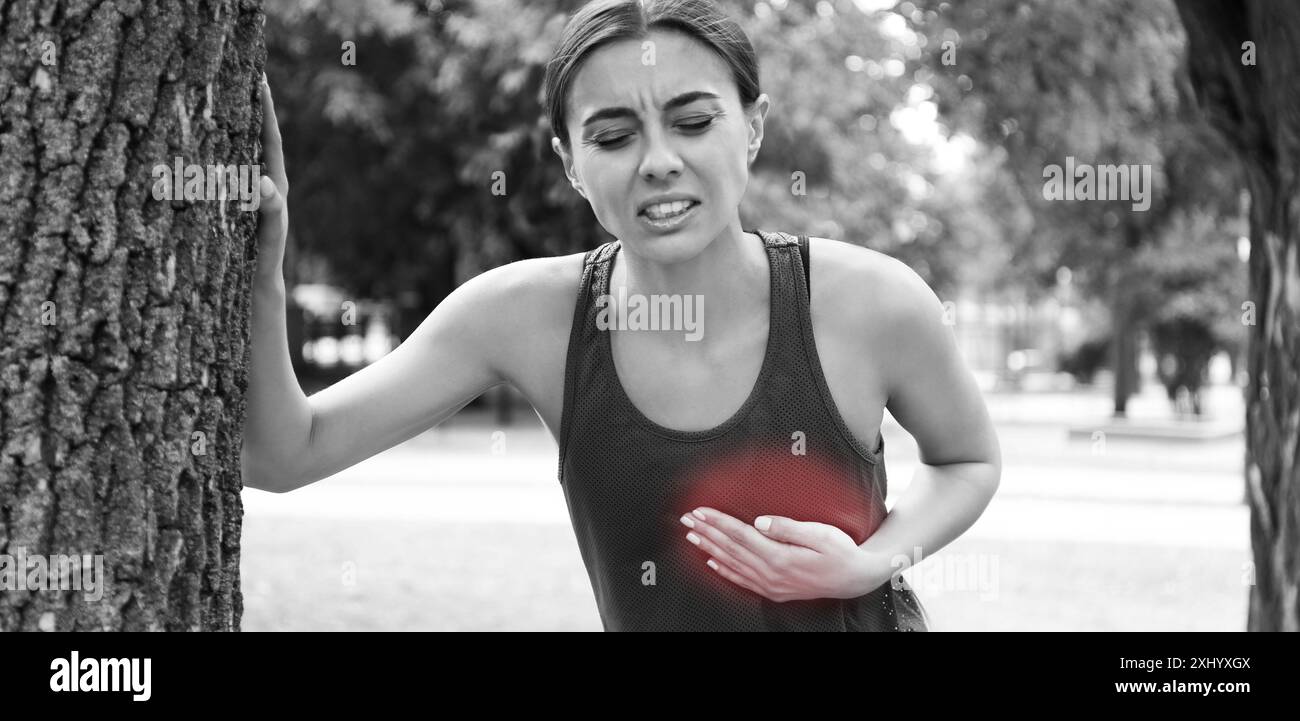 Heart attack. Young woman suffering from pain in chest and leaning on ...