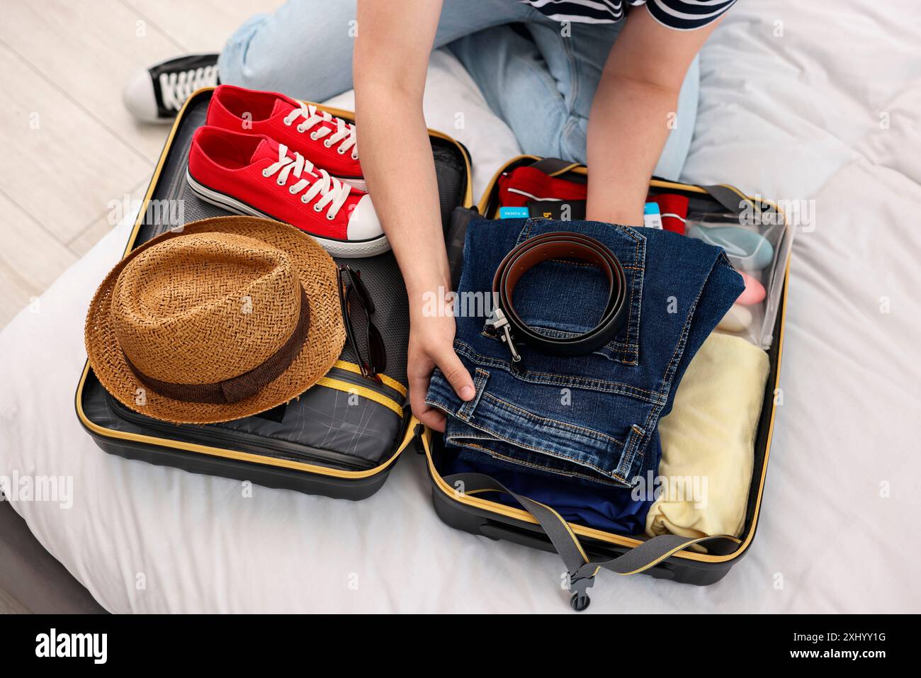 Man packing suitcase on bed hi-res stock photography and images - Alamy
