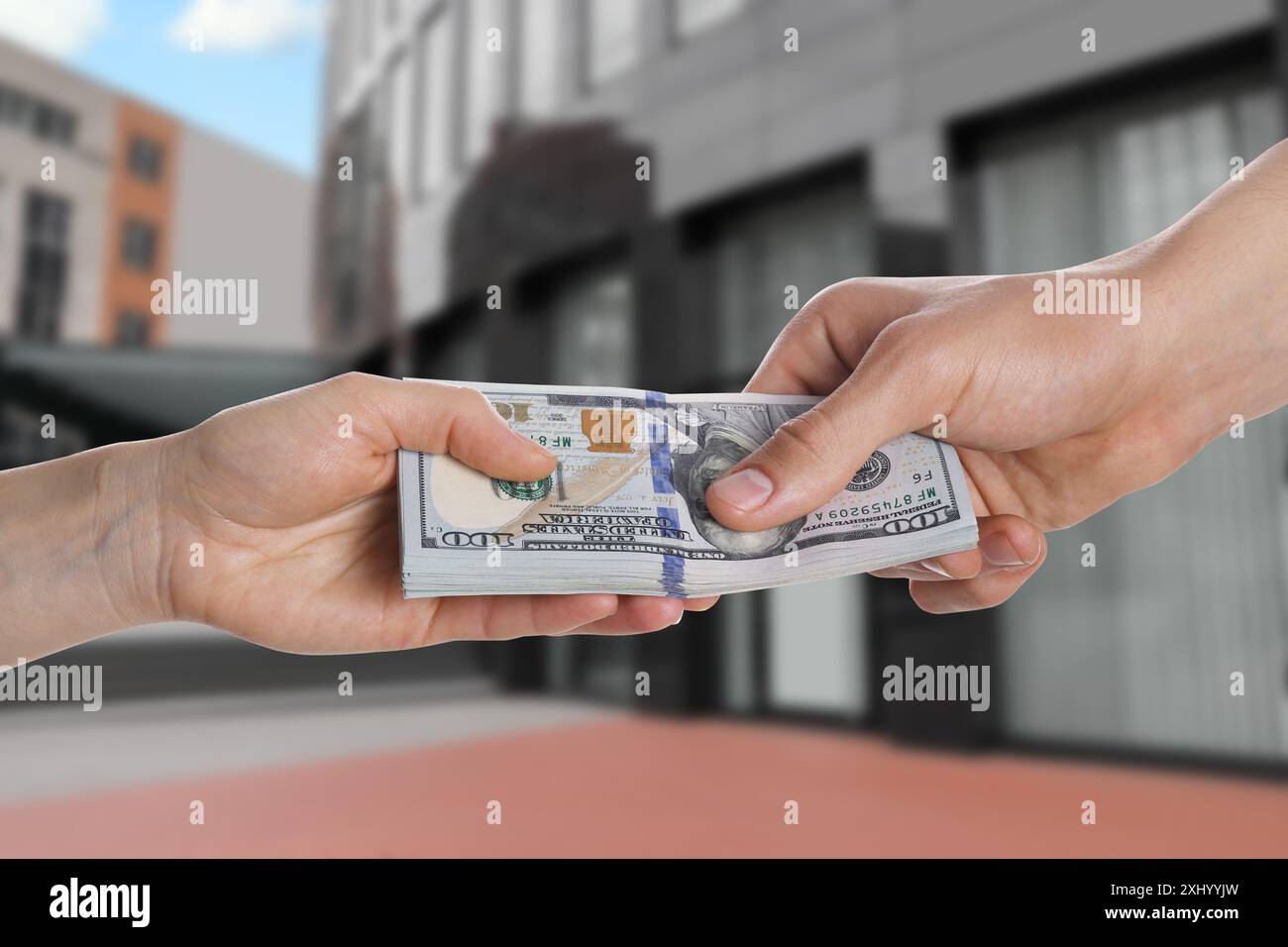 Client giving money to real estate agent against building, closeup ...