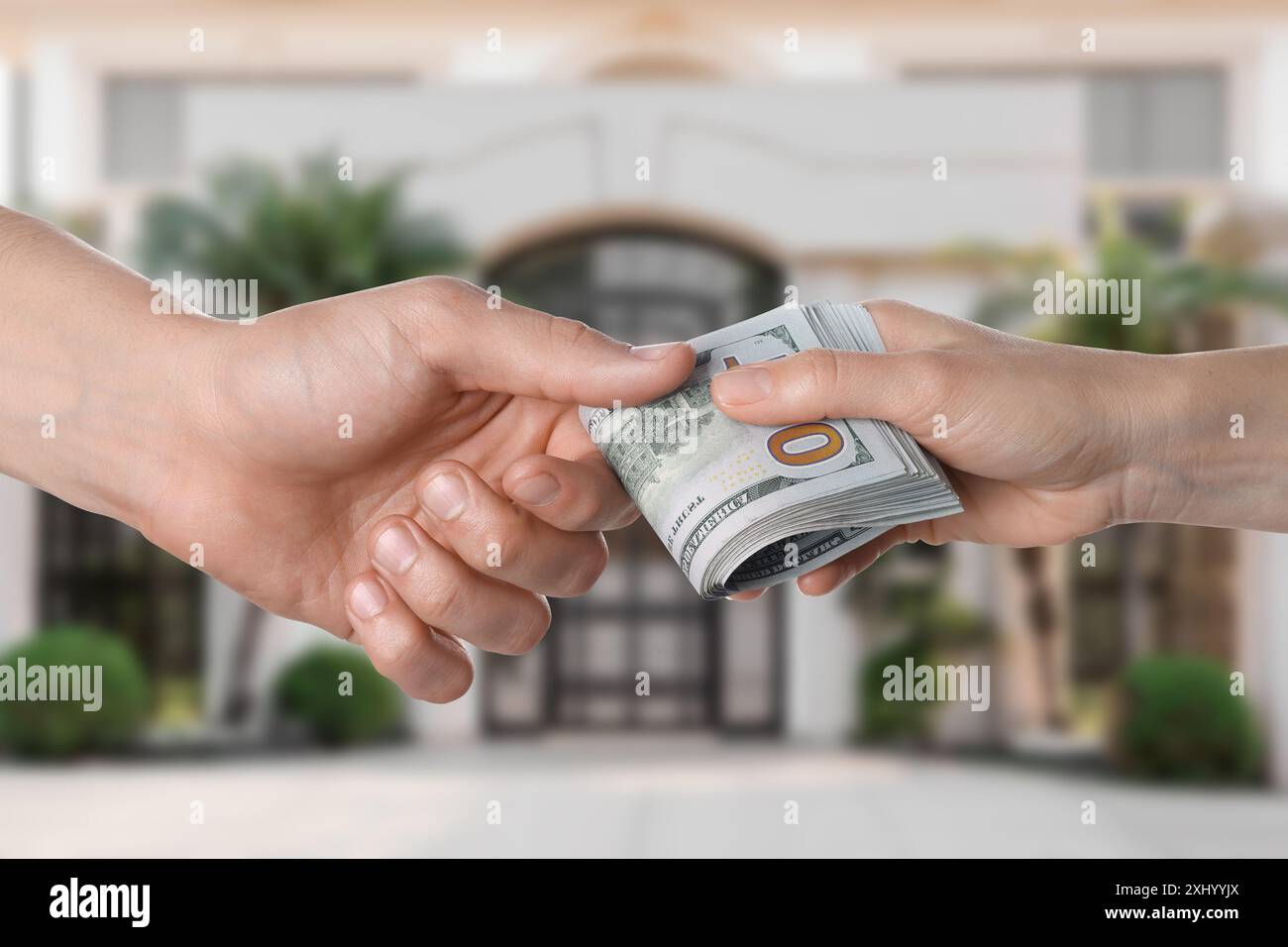 Client giving money to real estate agent against beautiful house ...