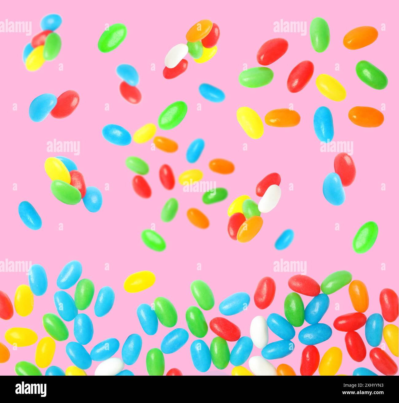 Many sweet jelly candies falling on pink background Stock Photo - Alamy