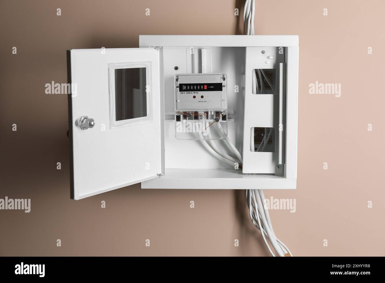 Electric meter in fuse box on beige wall. Energy measuring device Stock ...