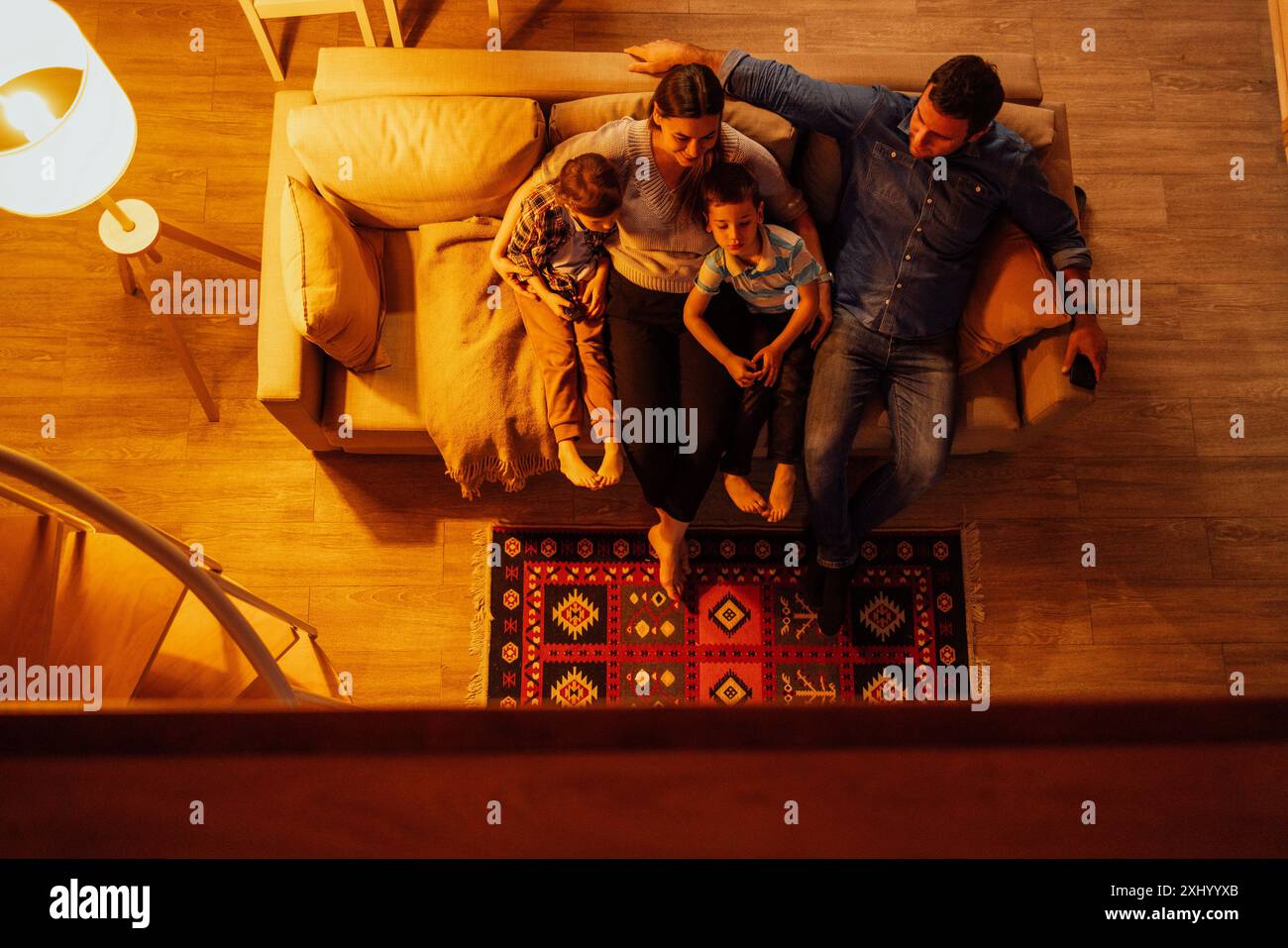 A young married couple with children is relaxing in the living room. A ...