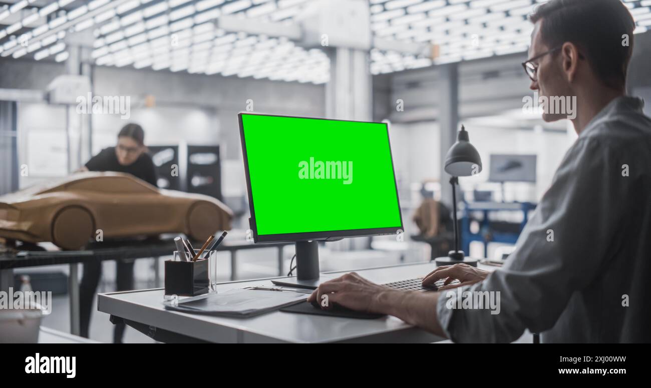 Automotive Designer Working on Desktop Computer with Green Screen Mock Up Display. Digital ...