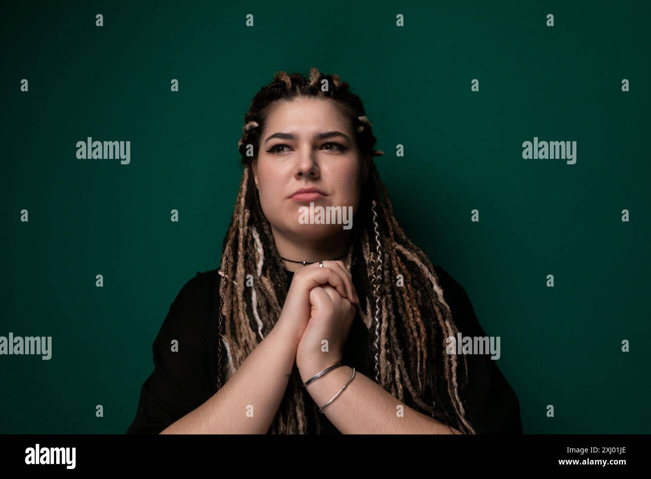 A woman with dreadlocks is standing confidently in front of a vivid ...