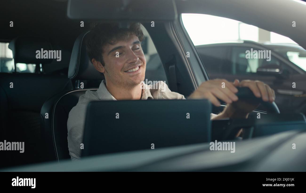 Carefree Caucasian driver man sit inside car turning on radio dancing ...