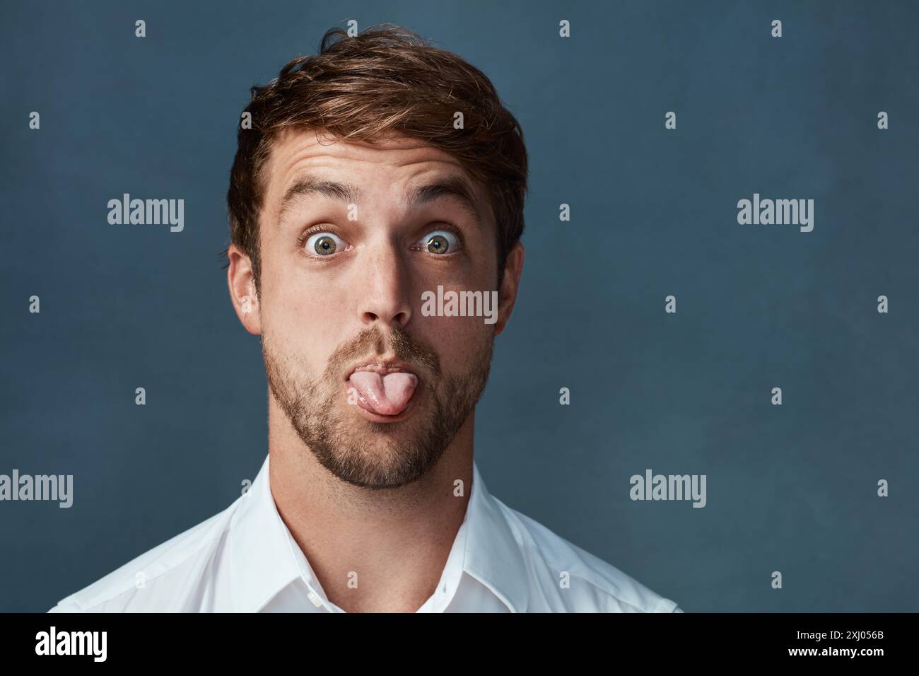 Tongue out, portrait and man in studio, happy and comic with confidence ...