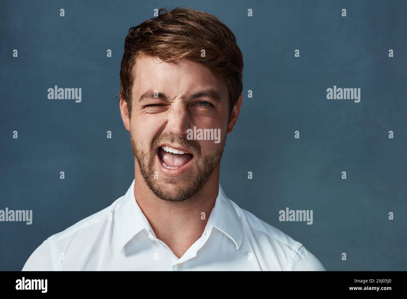 Wink, portrait and man in studio, happy and comic with confidence of ...
