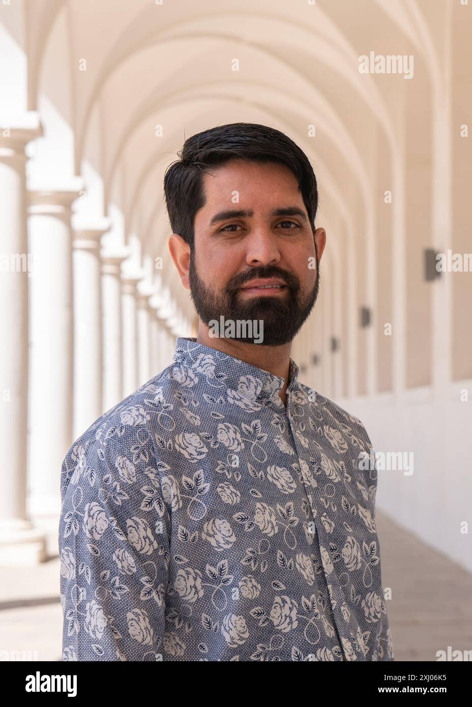 A modern, stylish Pakistani man with a dark beard and light clothes ...