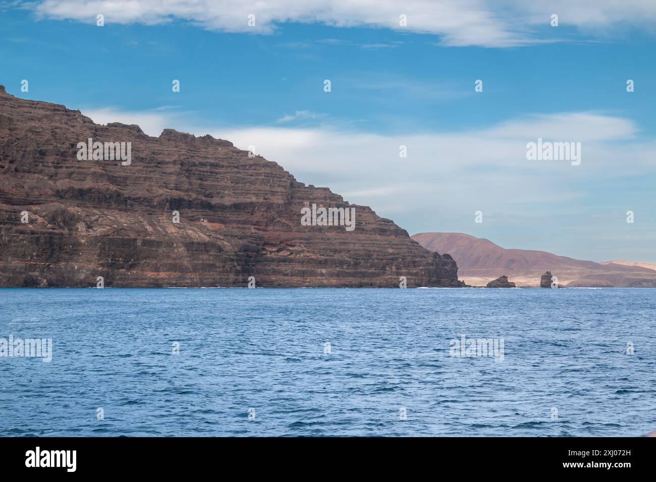 View from a boat on the volcanic cliffs and rocks in the north of the ...