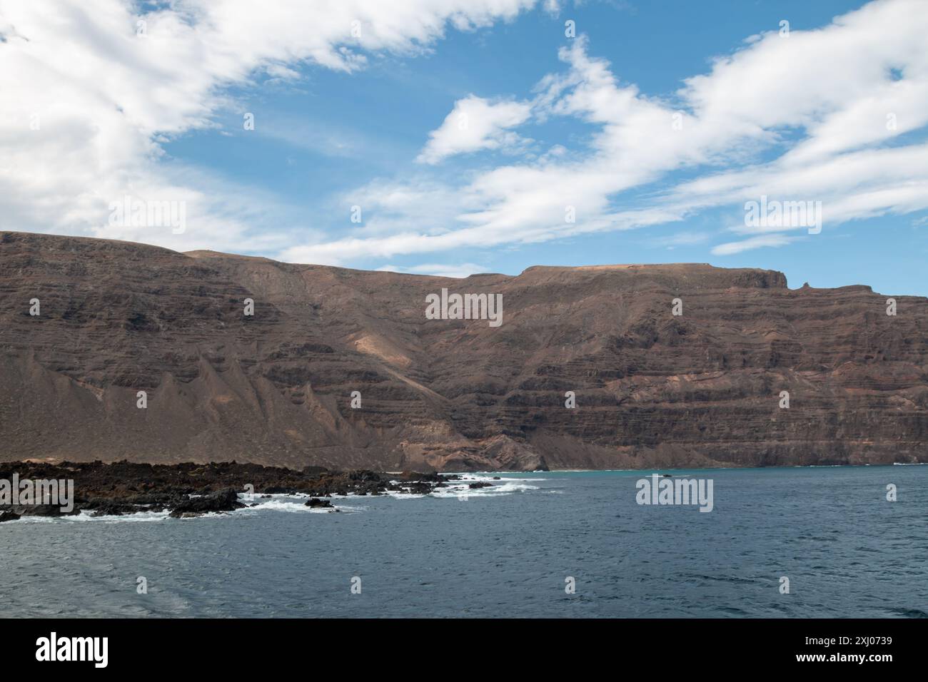View from a boat on the volcanic cliffs and rocks in the north of the ...