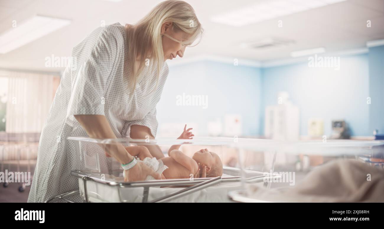Mother Putting Down a Newborn Child on a Hospital Bassinet Bed in a ...