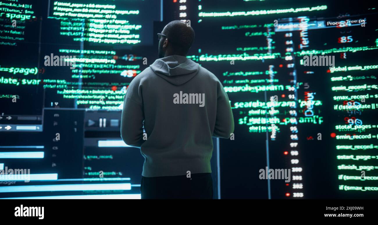 Back View of Young Black Man Looking Towards a Big Digital Screens Glitching While Displaying ...