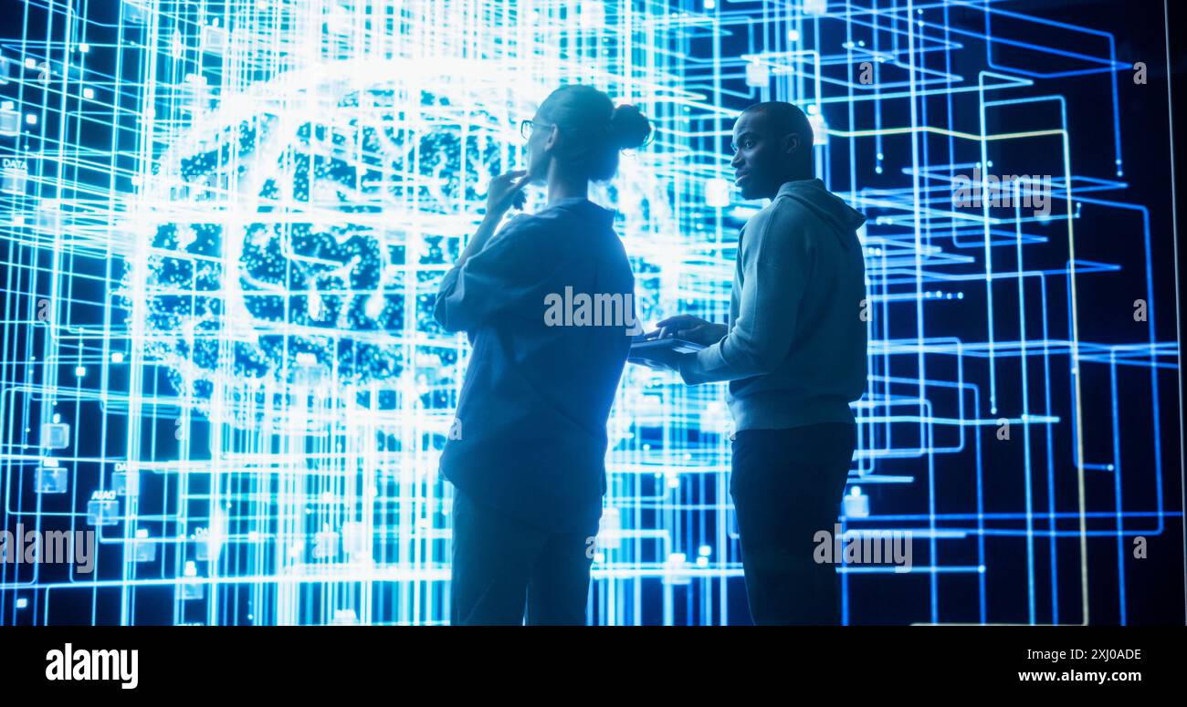 Portrait of Two Diverse Colleagues Looking at a Big Screen with Neural ...
