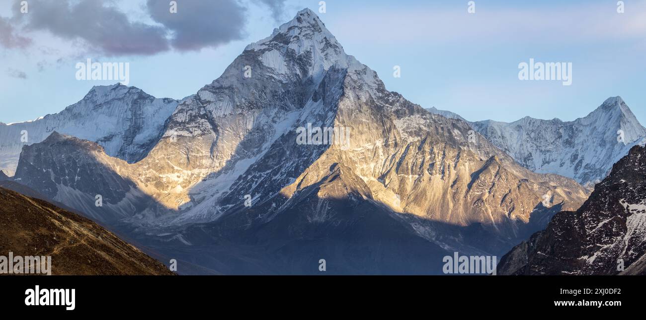 Ama Dablam mountain at sunset and blue sky. Sun illuminates slopes ...
