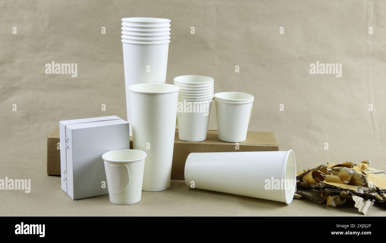 White paper coffee cup, used paper, and cardboard box on a brown ...
