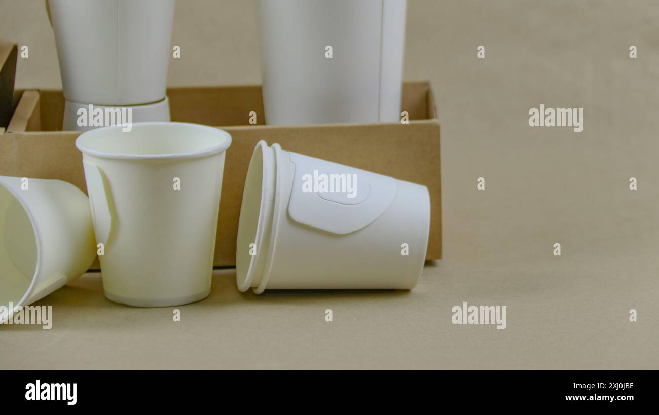 White paper coffee cup, used paper, and cardboard box on a brown ...