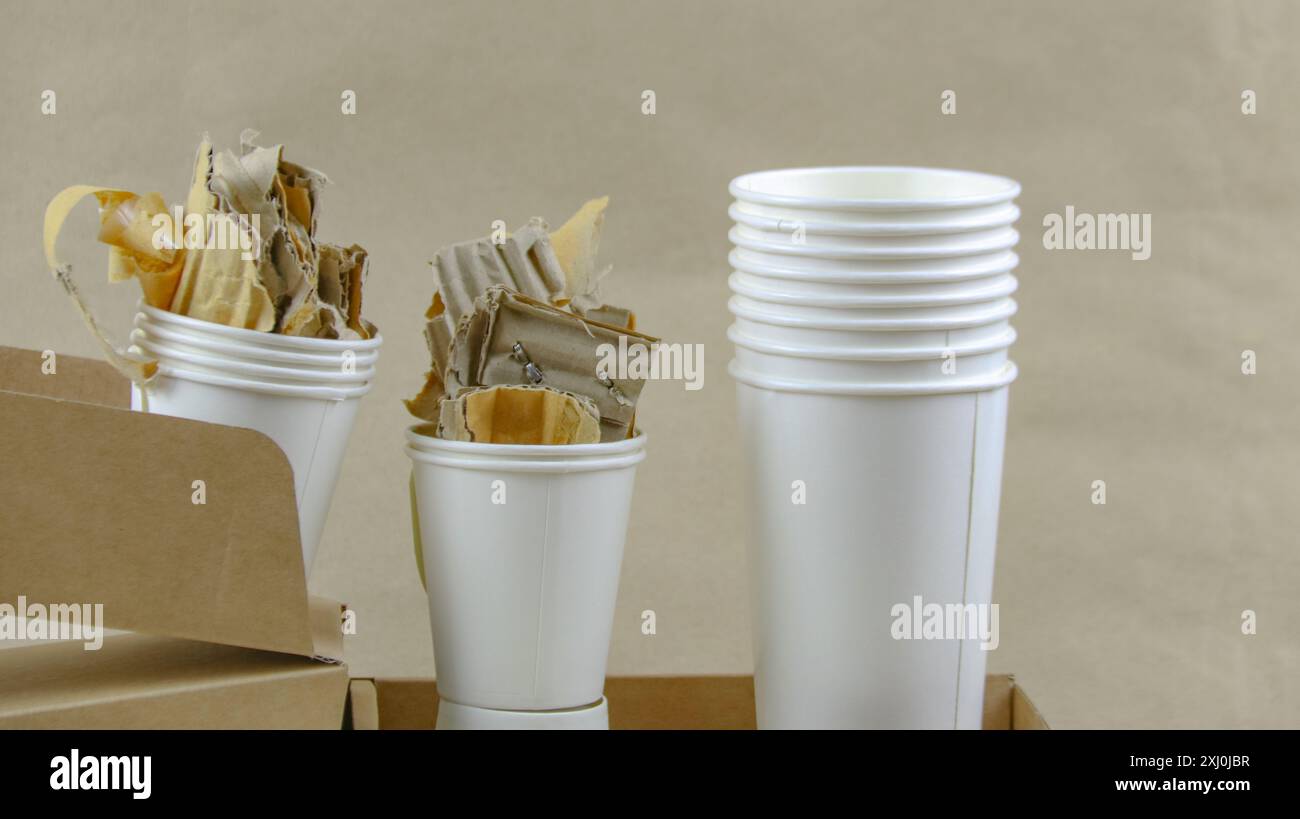 White paper coffee cup, used paper, and cardboard box on a brown ...