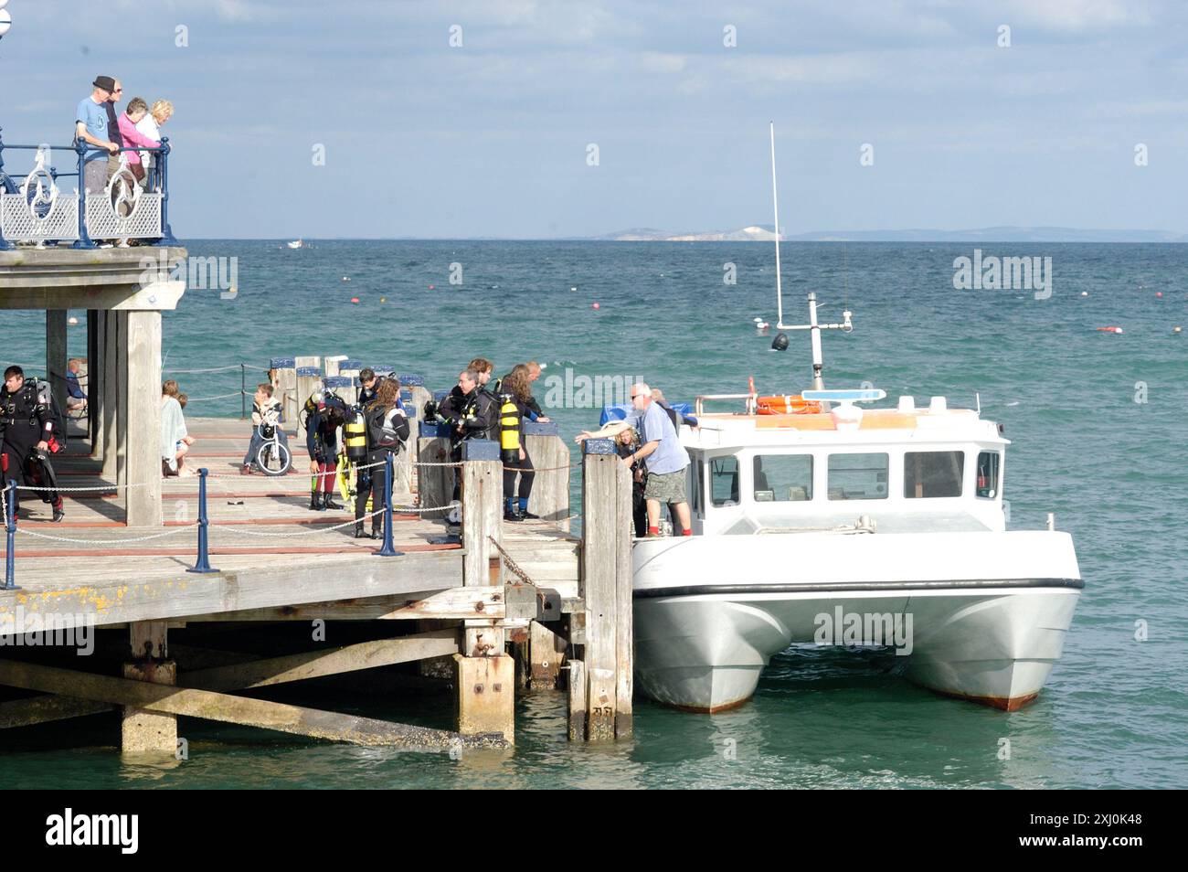 Divers disembarking from a Catamaran onto Swanage Pier Dorset England ...