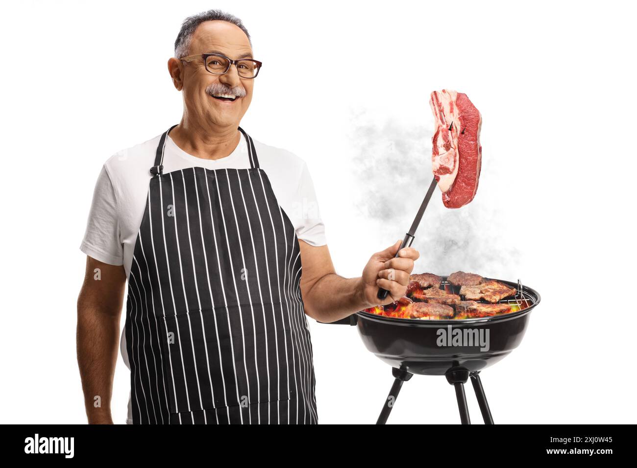 Mature man grilling meat on a barbecue and holding a sirloin steak ...
