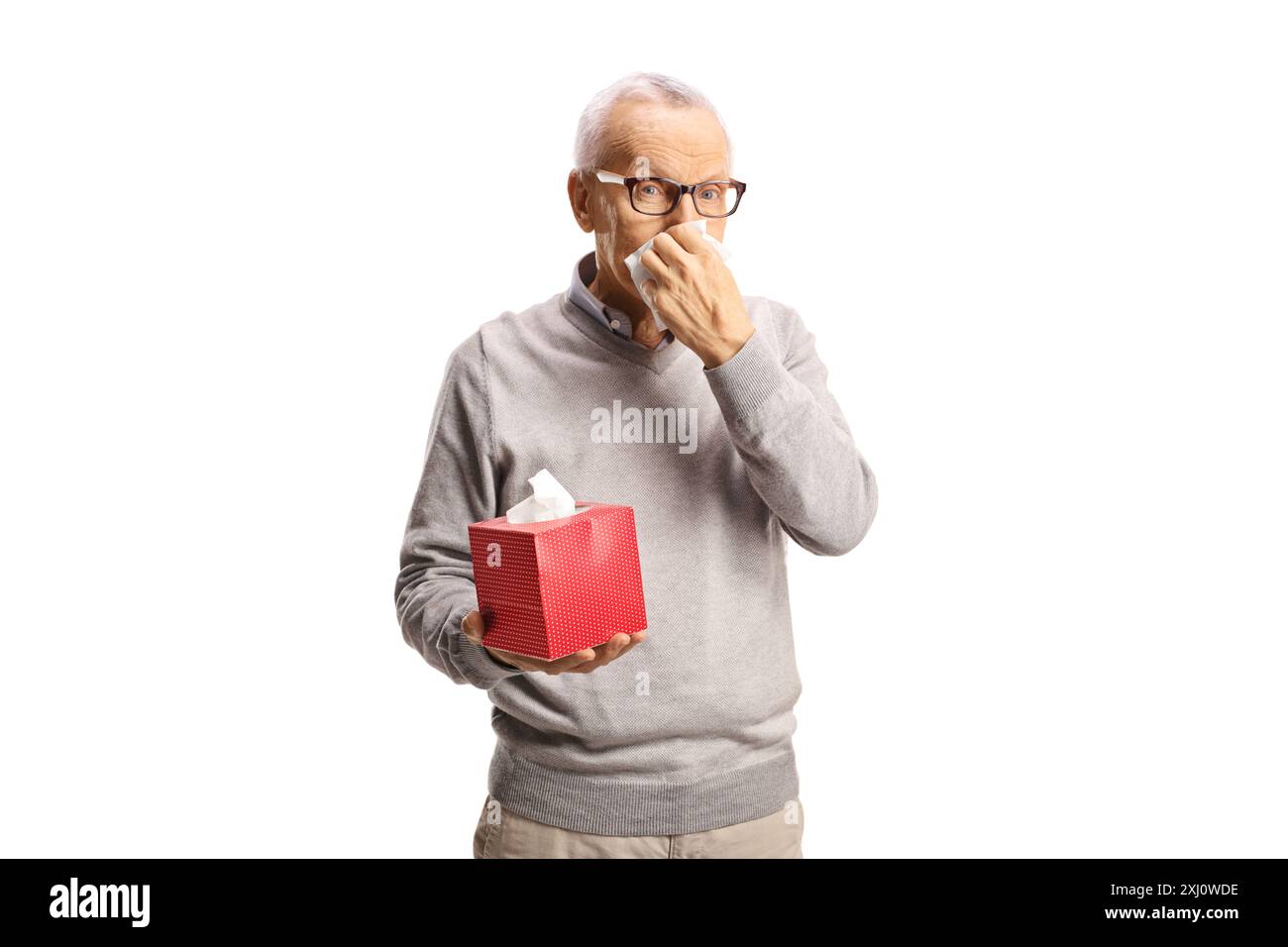 Elderly man blowing nose and holding a box of paper tissues isolated on ...