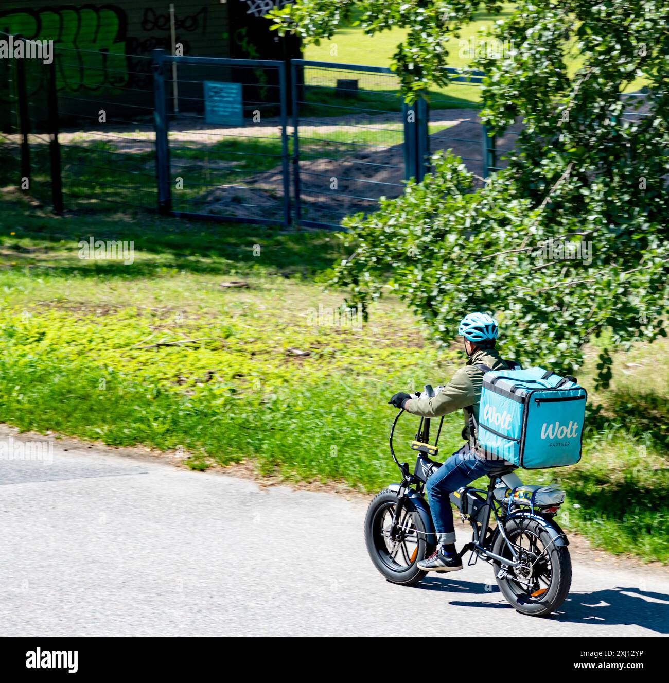 Wolt courier on an electric bike in Mustapuronpolku, Myllypuro ...