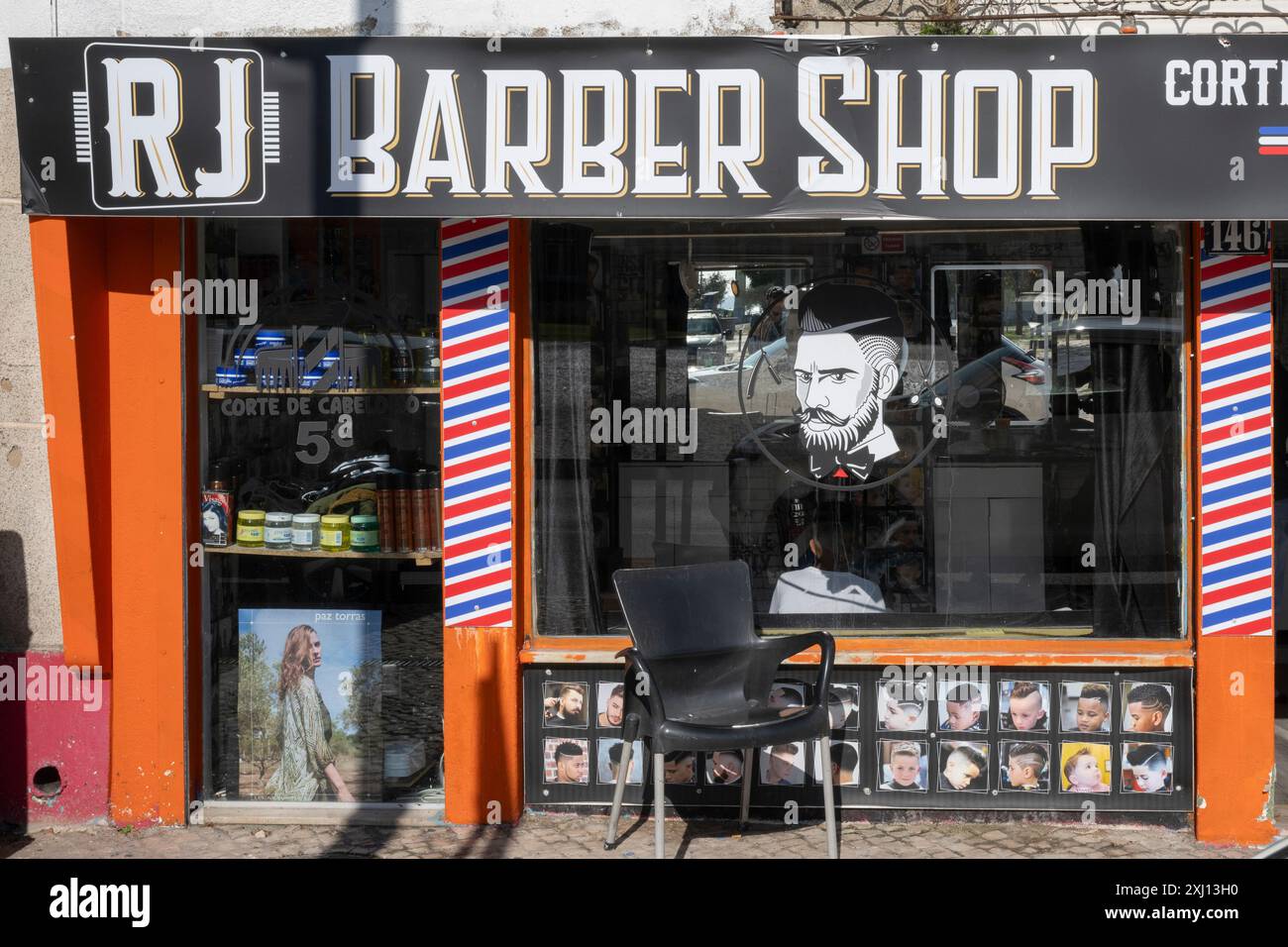 Front view of a barber shop storefront in Setúbal which is a busy port and industrial city in ...