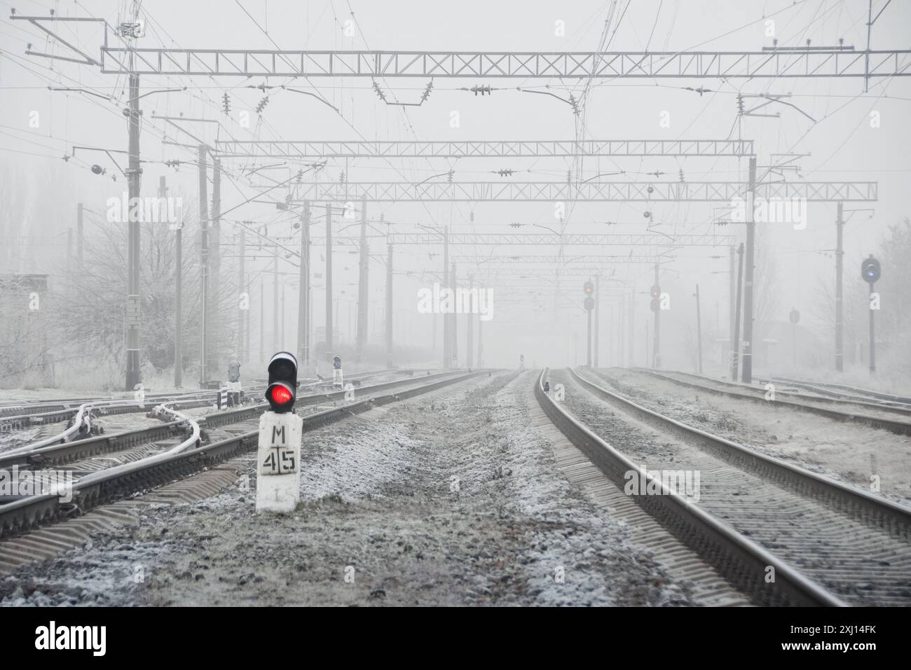 Railway tracks in a fog. Red signal light on railway semaphore. Low ...