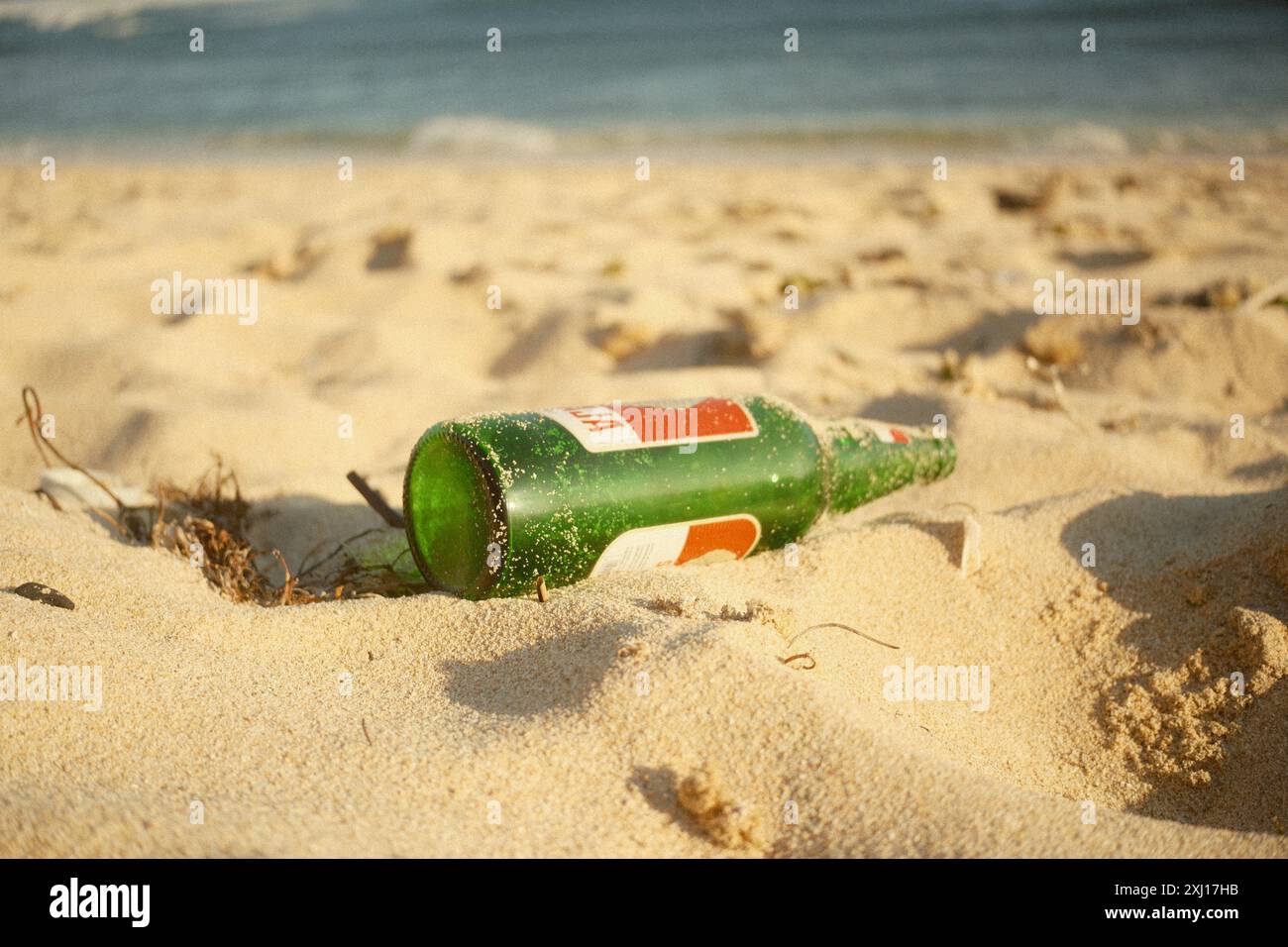 Discarded beer glass bottle waste is on the sandy beach Stock Photo - Alamy
