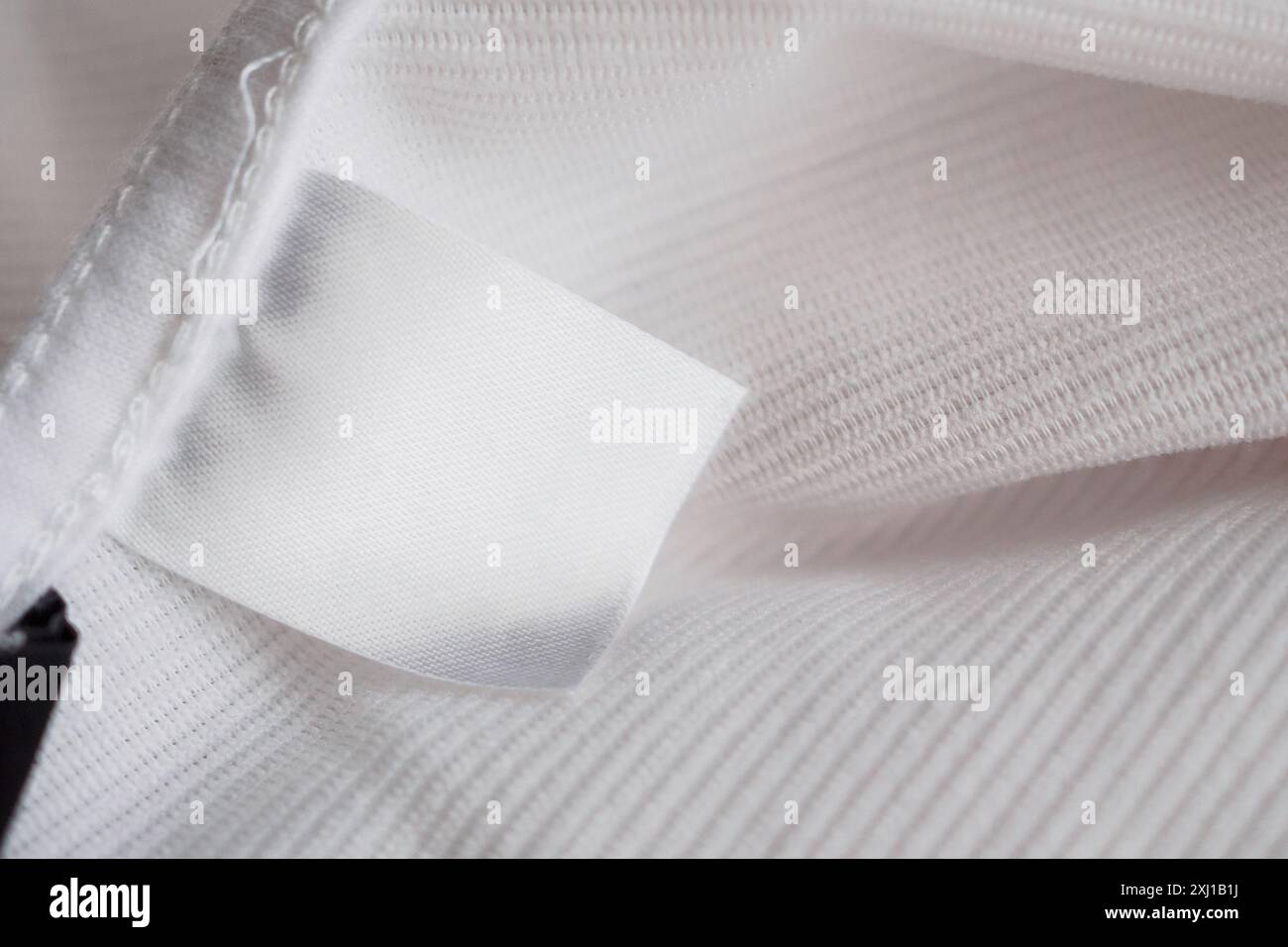 White blank clothing label on cotton shirt background Stock Photo - Alamy