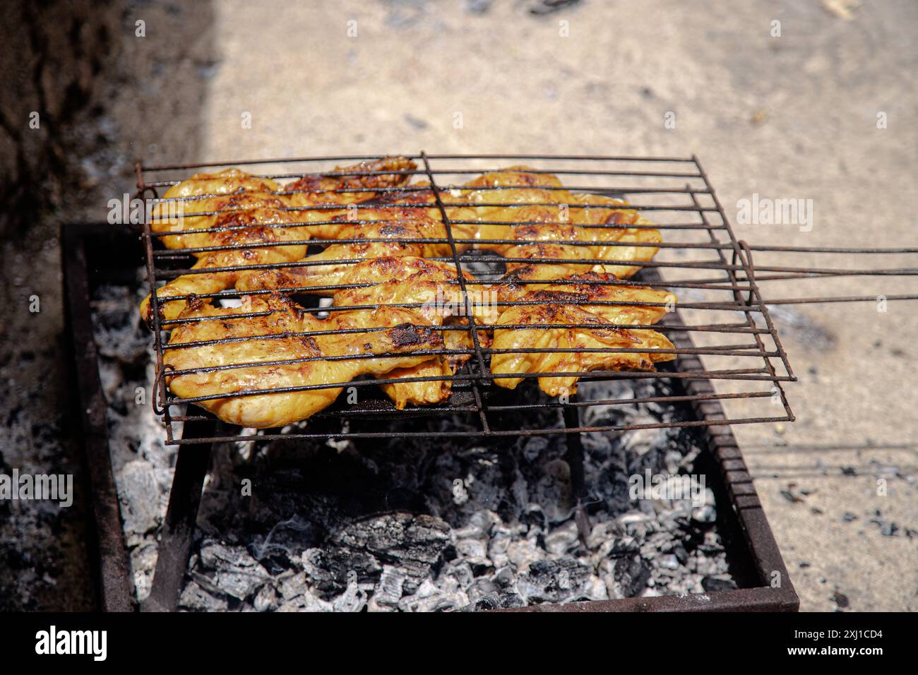 Juicy, seasoned chicken pieces are grilled to perfection on a metal ...