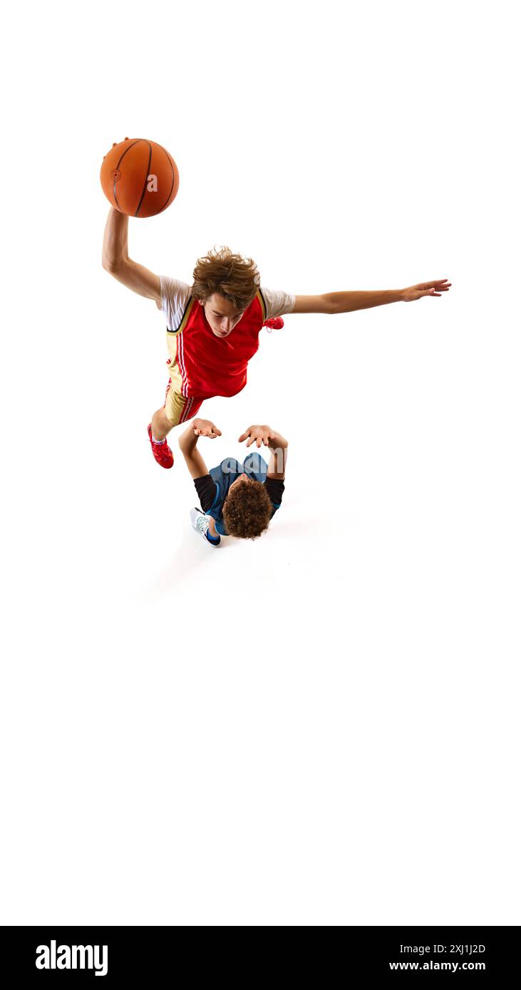 Basketball player in red jersey leaps high, ready to dunk the ball, as ...
