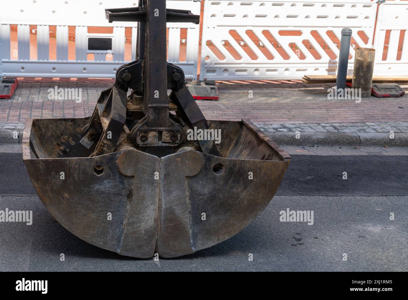 The image captures the clamshell bucket of an excavator positioned on a ...
