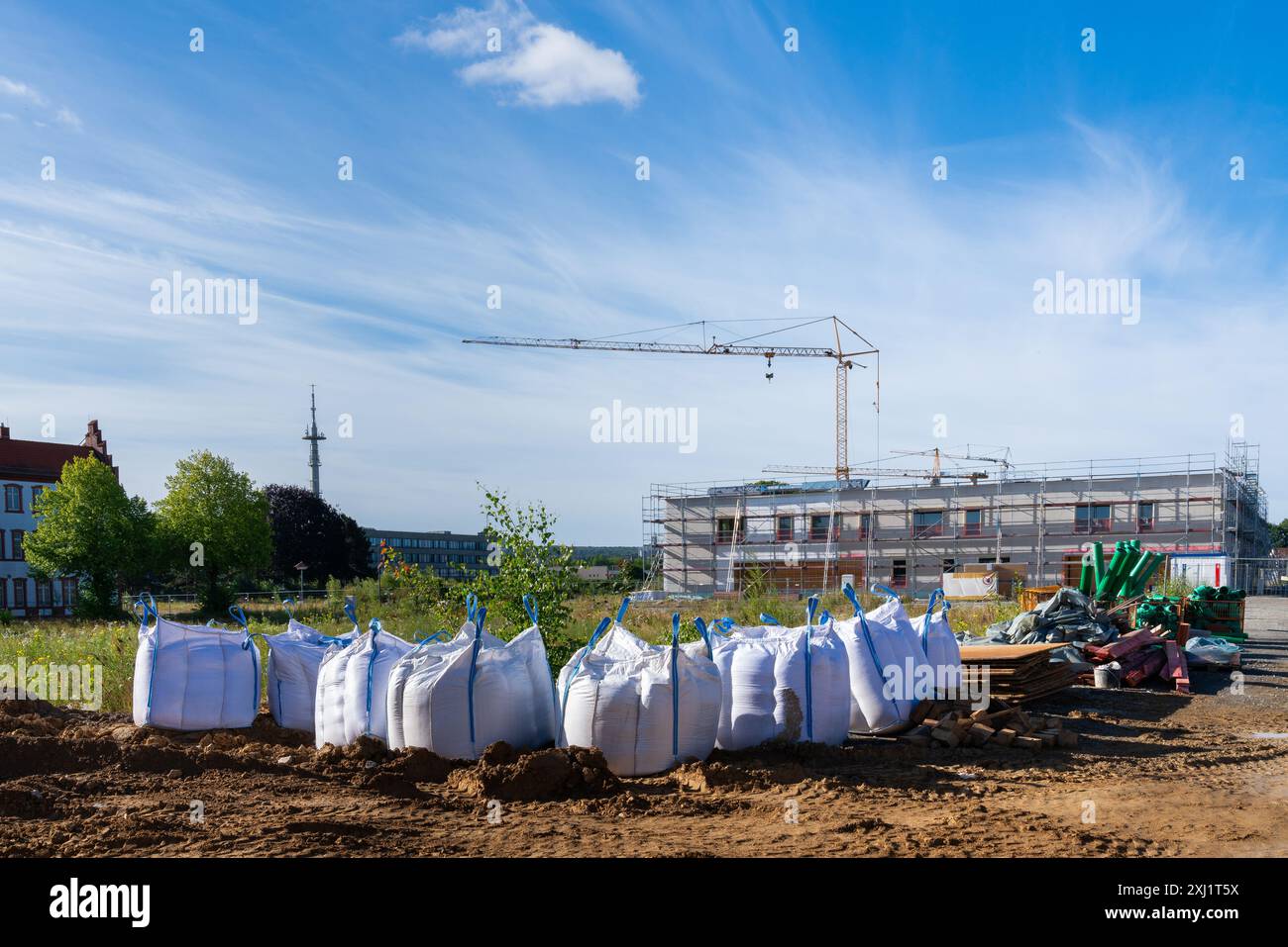 A construction site with sandbags lining the edge of a cleared area. A ...