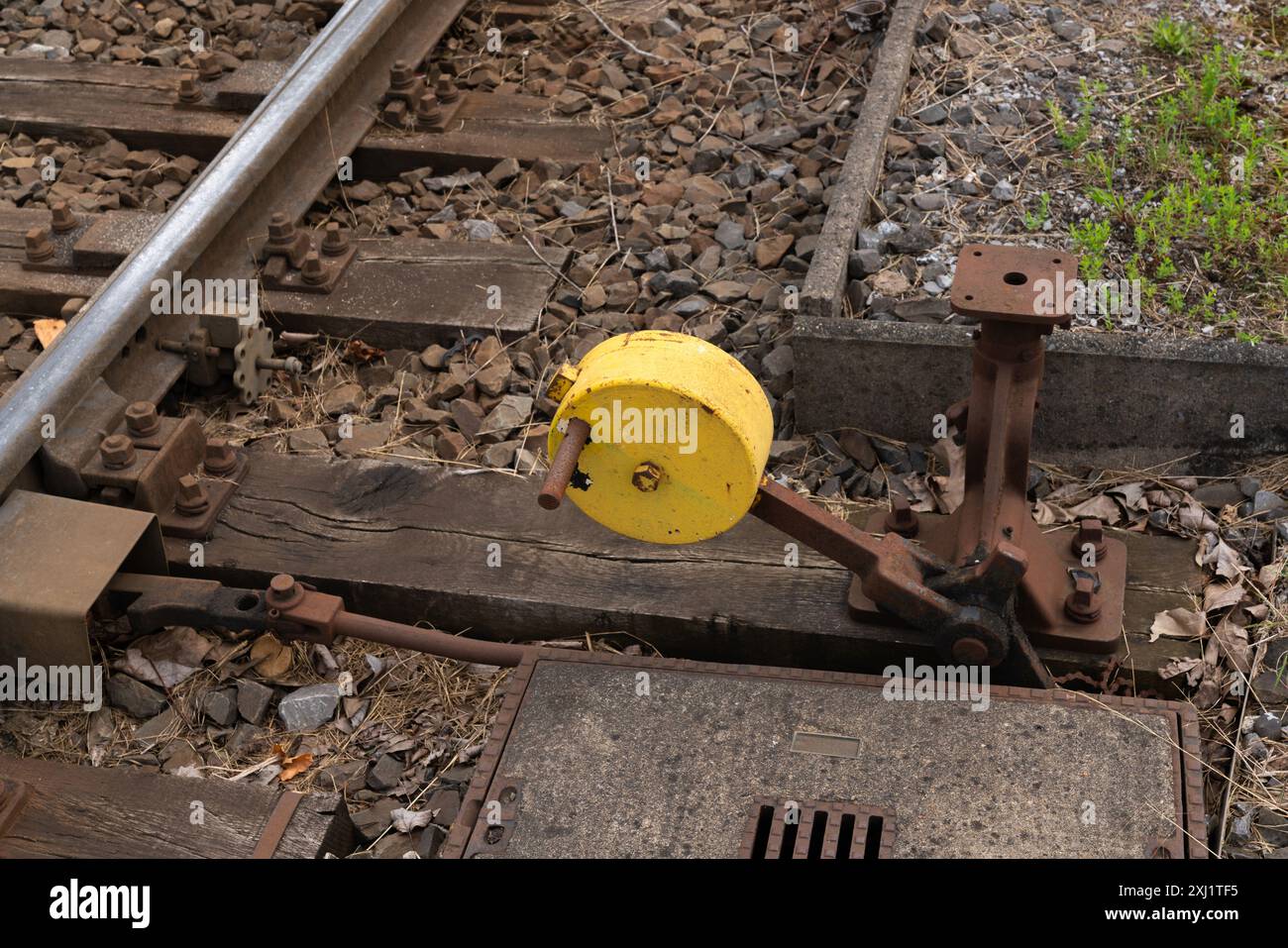 A yellow switch mechanism is located between two railway tracks ...