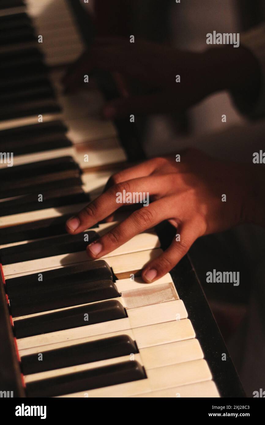 A captivating image of a black man's hands playing an old honky tonk ...
