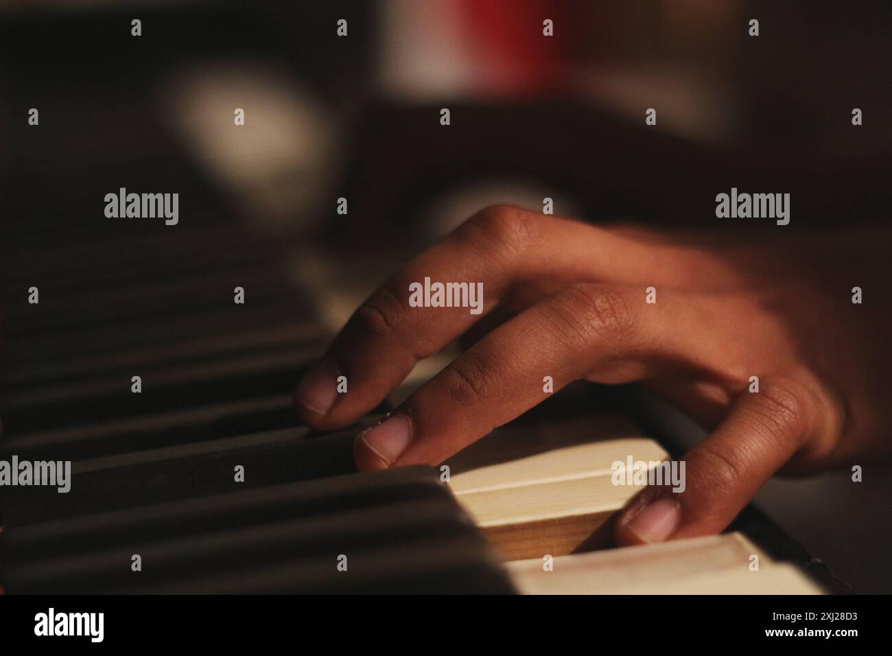 A captivating image of a black man's hands playing an old honky tonk ...