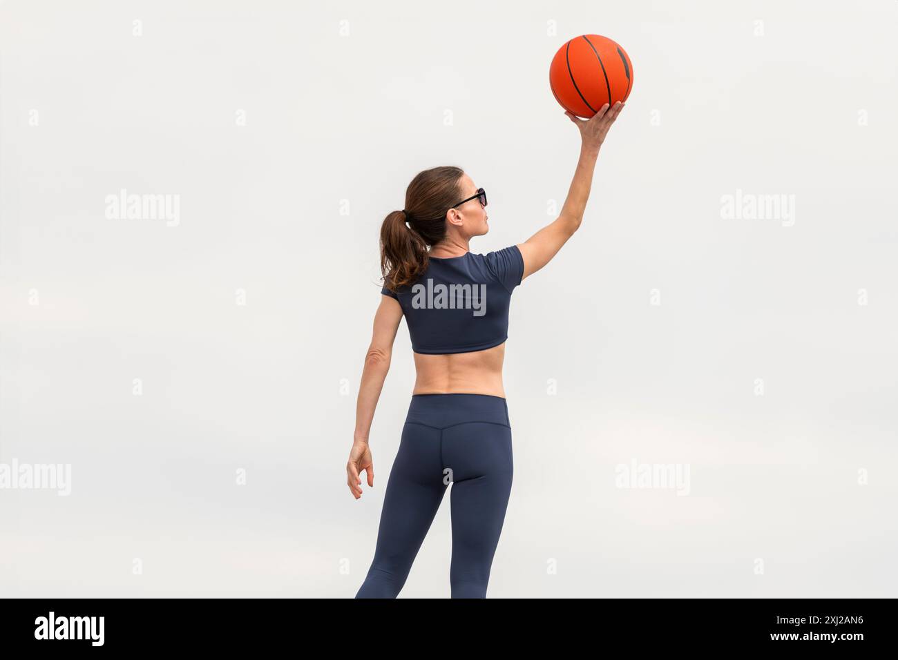 Mid adult sporty woman shooting hoops with a basketball Stock Photo - Alamy