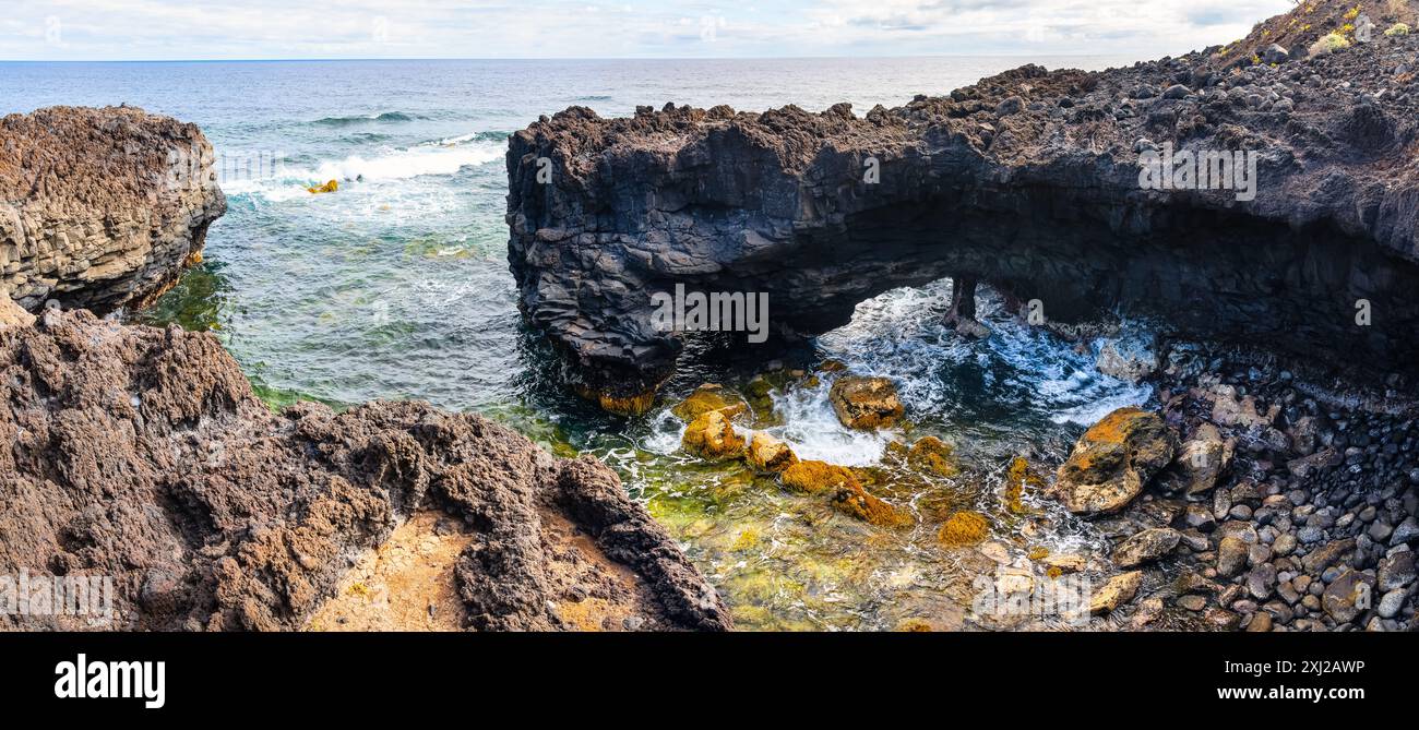 Cliff of volcanic rocks that form stone arches where the waves break ...