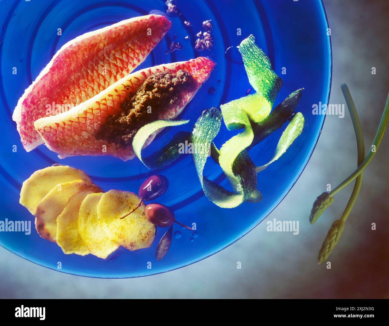 Red mullet fillets with new potatoes and zucchinis Stock Photo - Alamy