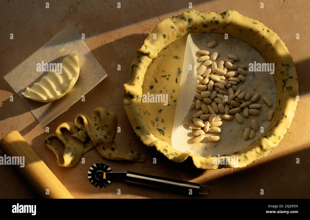 Placing the wax paper and beans in the uncooked pastry mould Stock ...