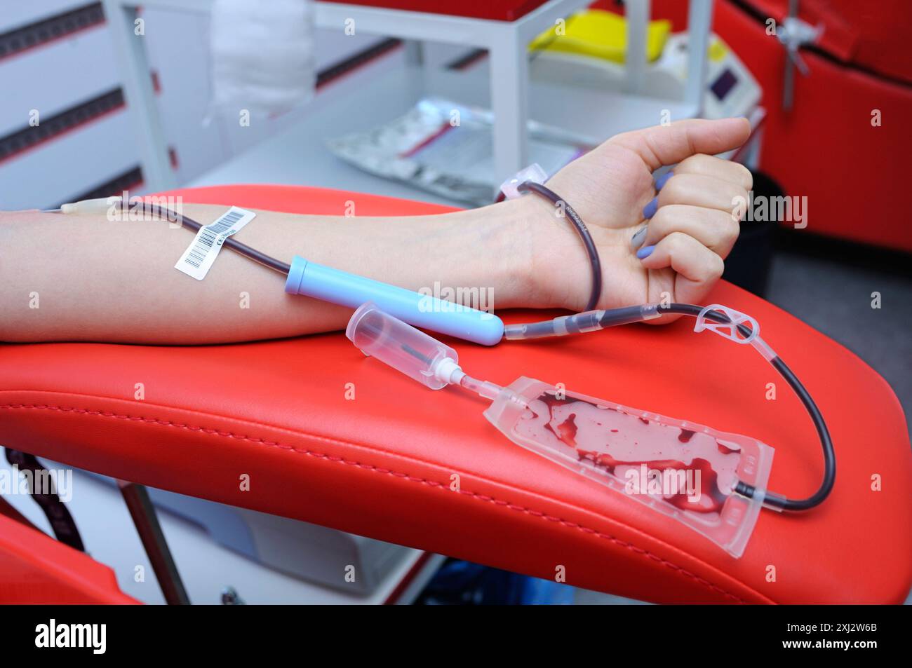 Taking blood from the vain of a donor. Arm on an armrest, hypodermic ...