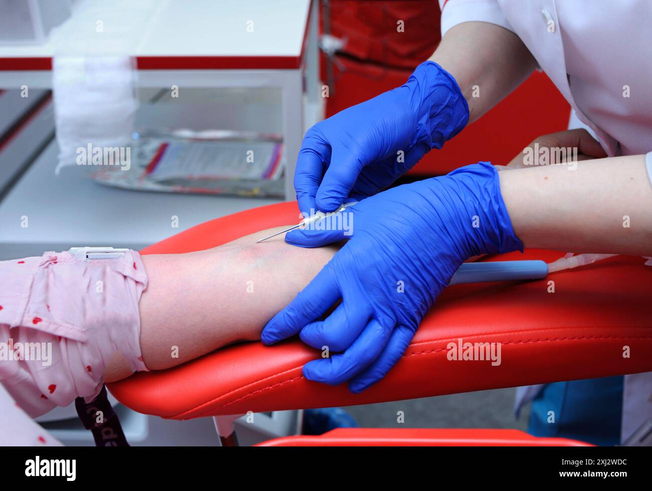 Nurse's hands taking blood from the vain of a donor - hypodermic needle ...