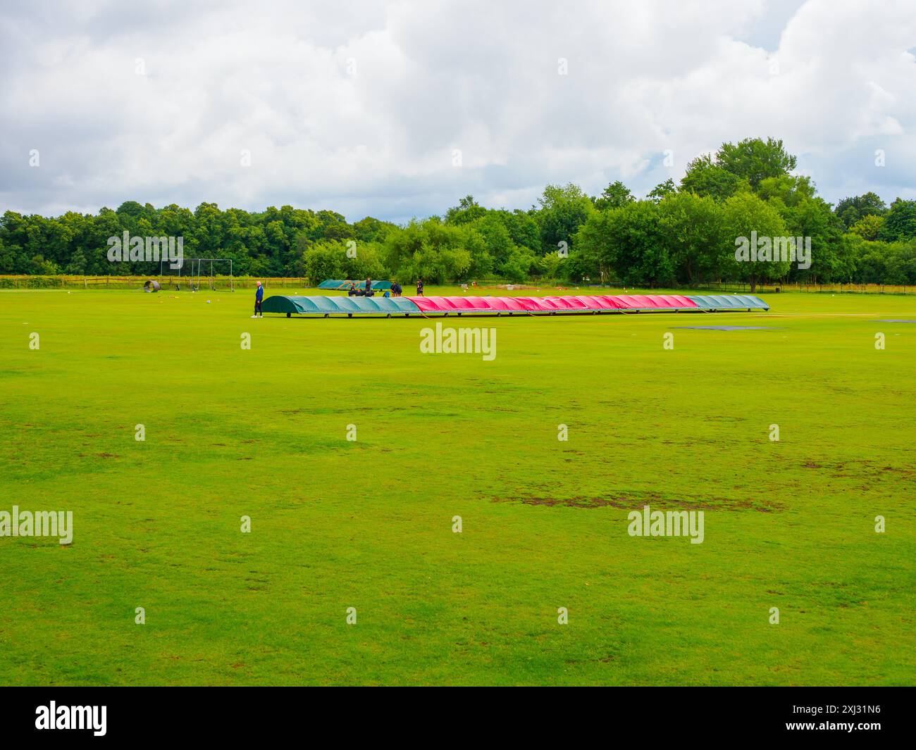 Colourful covers on a vast green cricket field Roe Green Worsley under ...