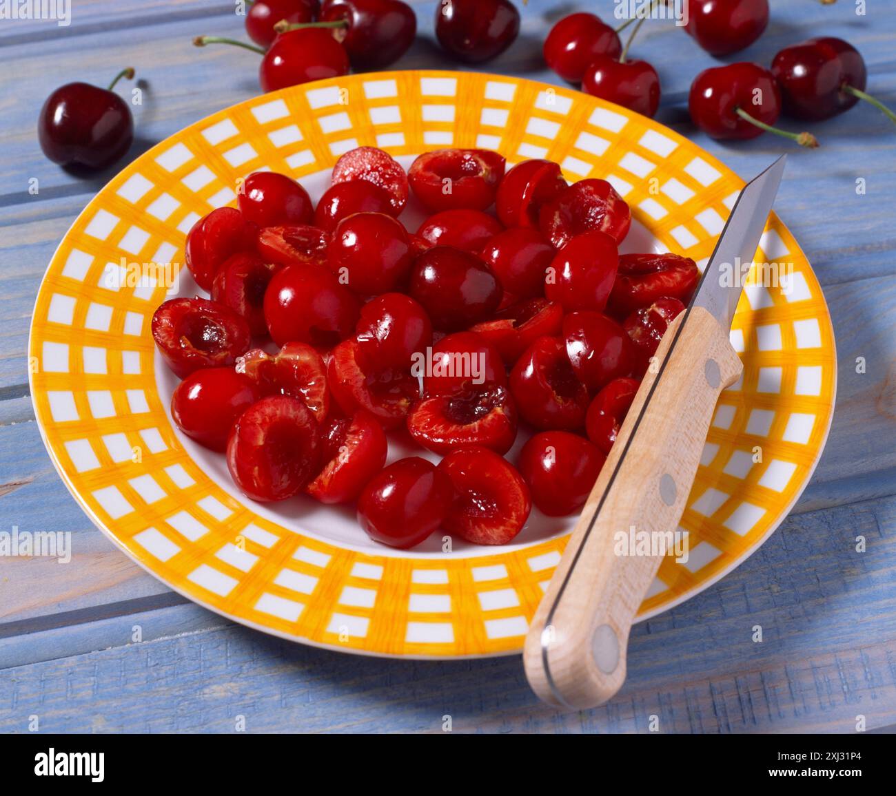 Cutting the cherries in half Stock Photo - Alamy