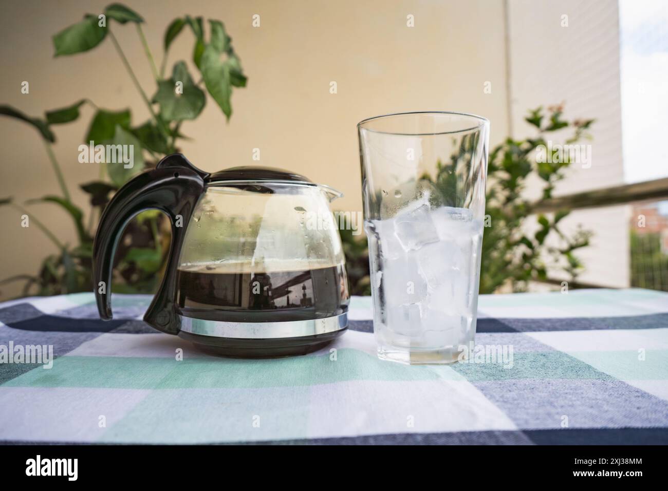 A Tall Glass with Ice in it with coffee pot on side for Cold brew ...
