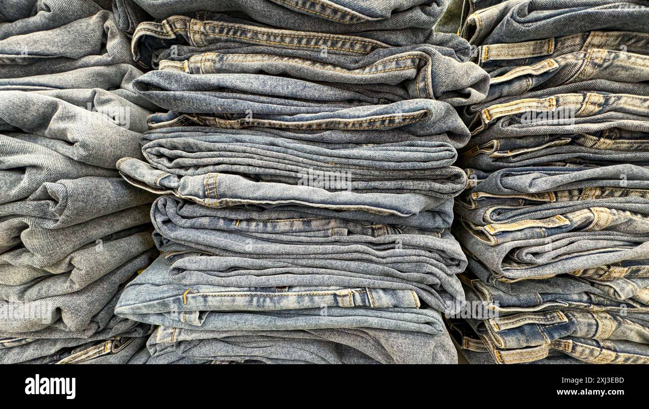 neatly folded stacks of blue jeans on display in a store Stock Photo ...