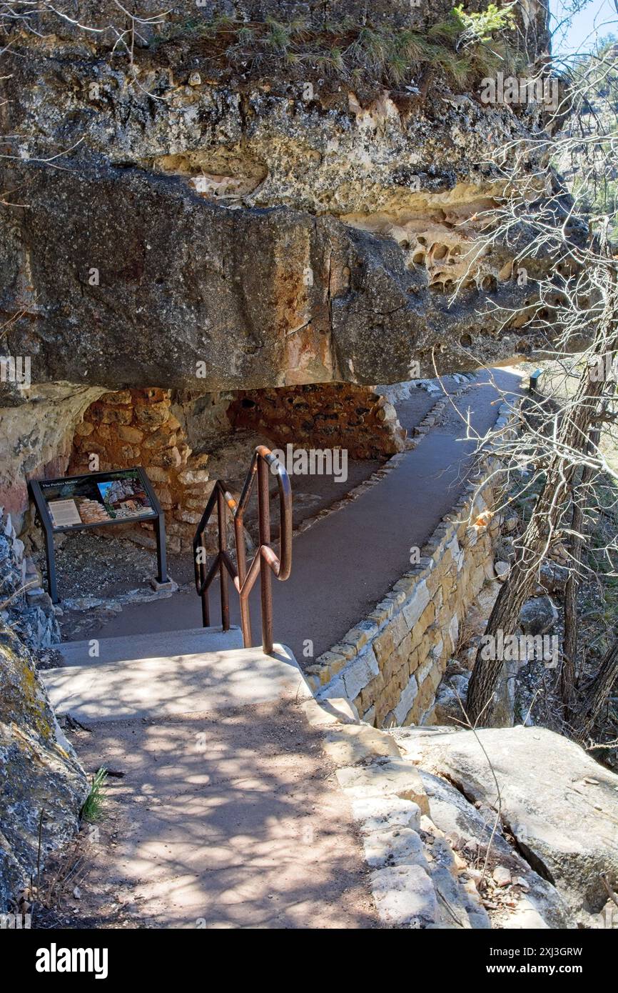 Ruins of cliff dwellings under limestone ledge with interpretive ...
