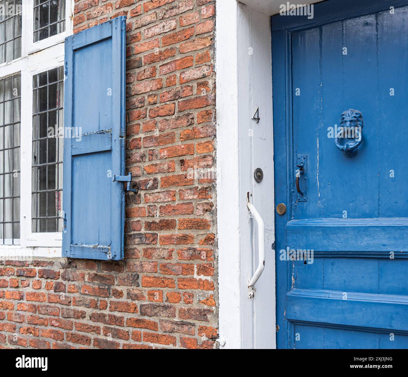 A door with a knocker and number is in the foreground and beyond is a ...