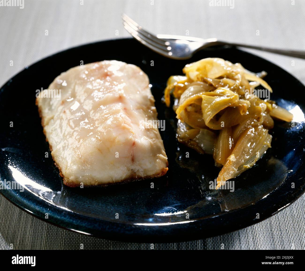Grilled bass cooked on one side and braised chicory Stock Photo - Alamy